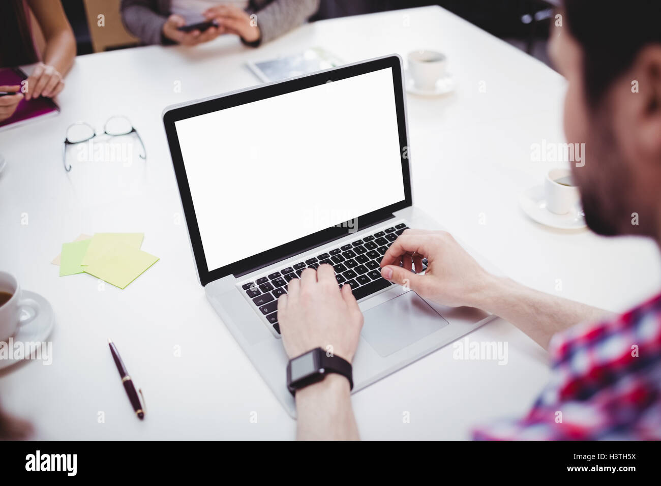 High angle view of executive using laptop in meeting room at creative ...