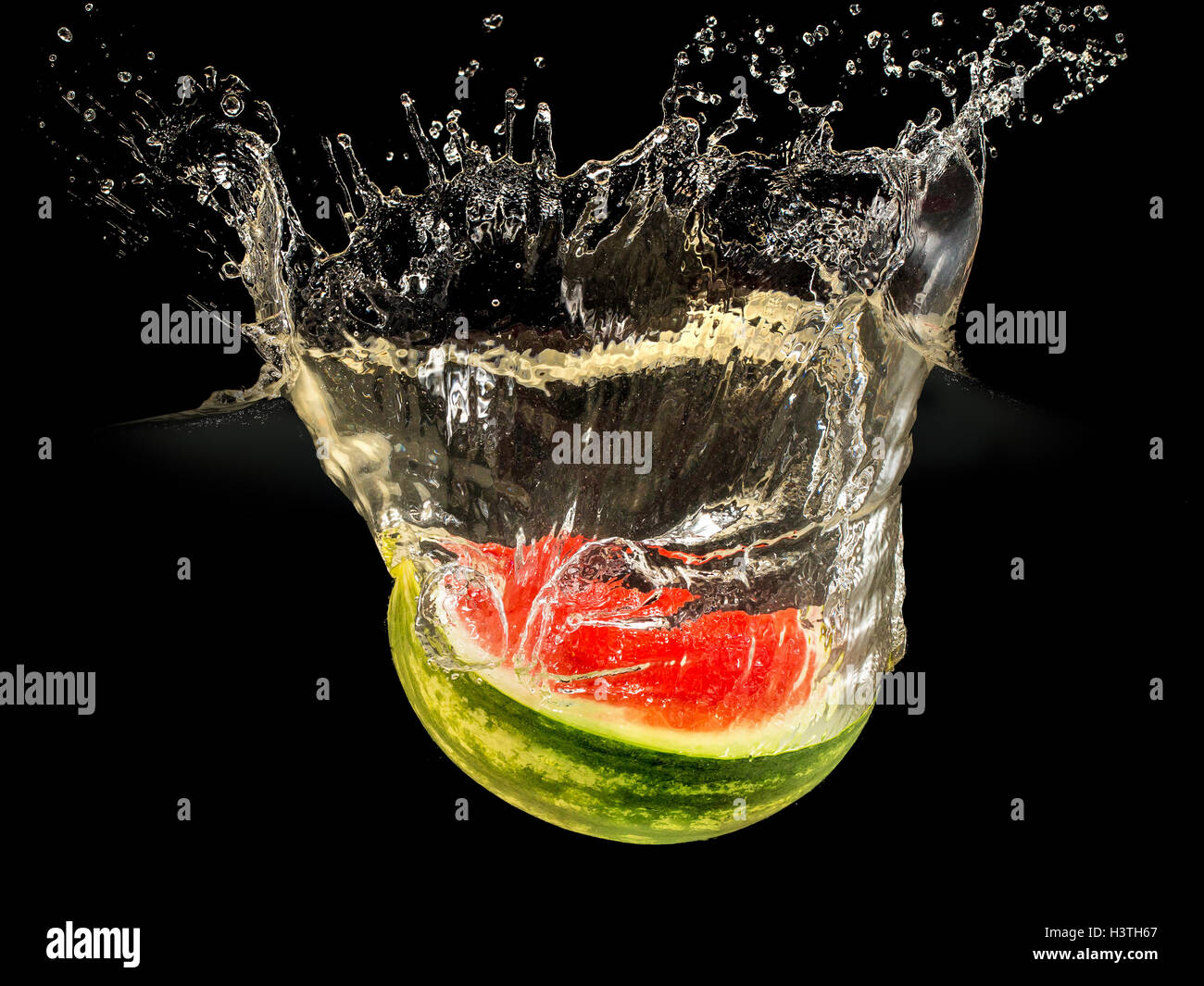 Fresh melon falling in water with splash on black Stock Photo - Alamy