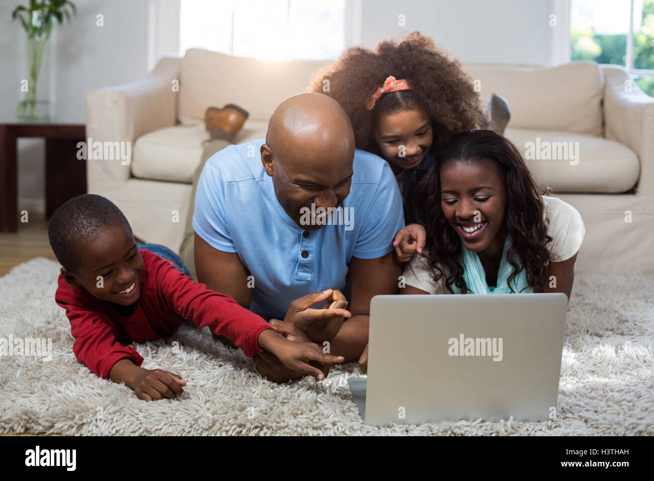 Happy family using laptop Stock Photo - Alamy