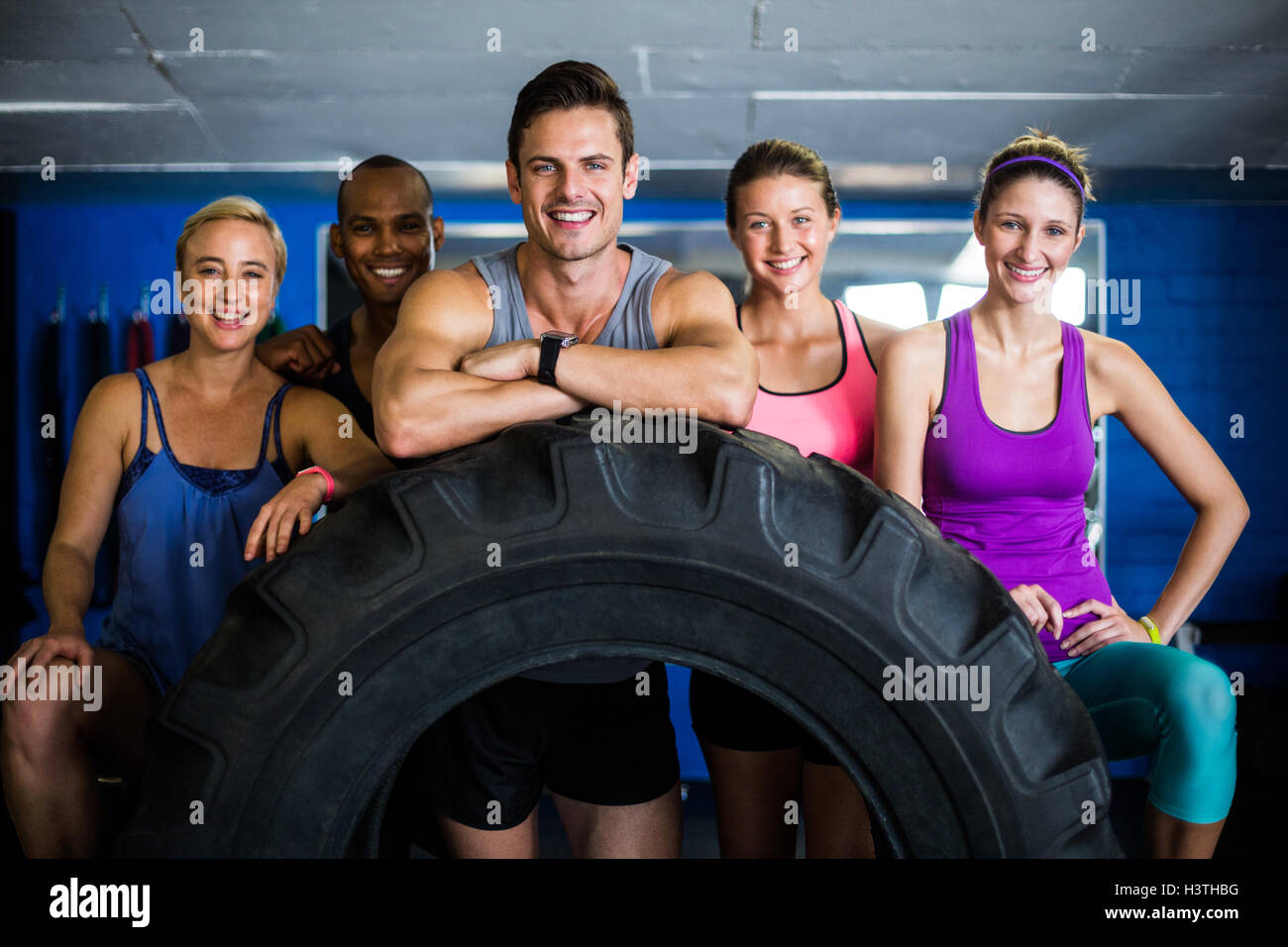 Portrait of smiling friends with tire in gym Stock Photo - Alamy