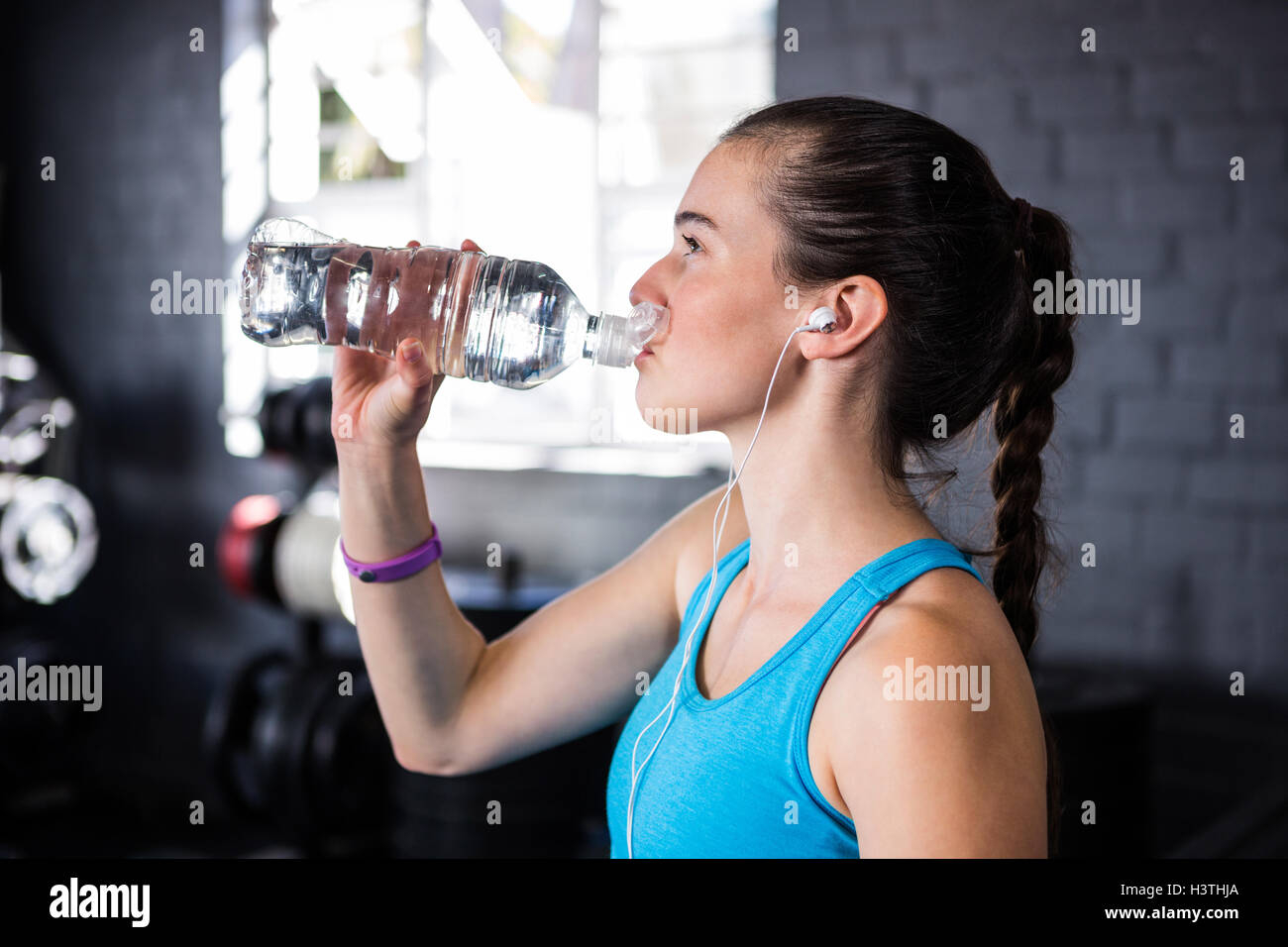 Female athlete drinking water in gym Stock Photo - Alamy