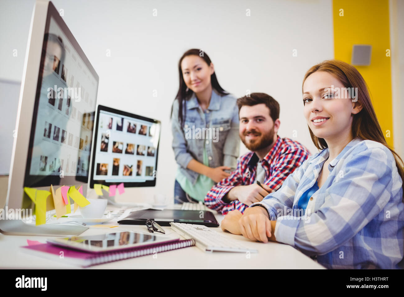 Smiling graphic designers at desk Stock Photo - Alamy