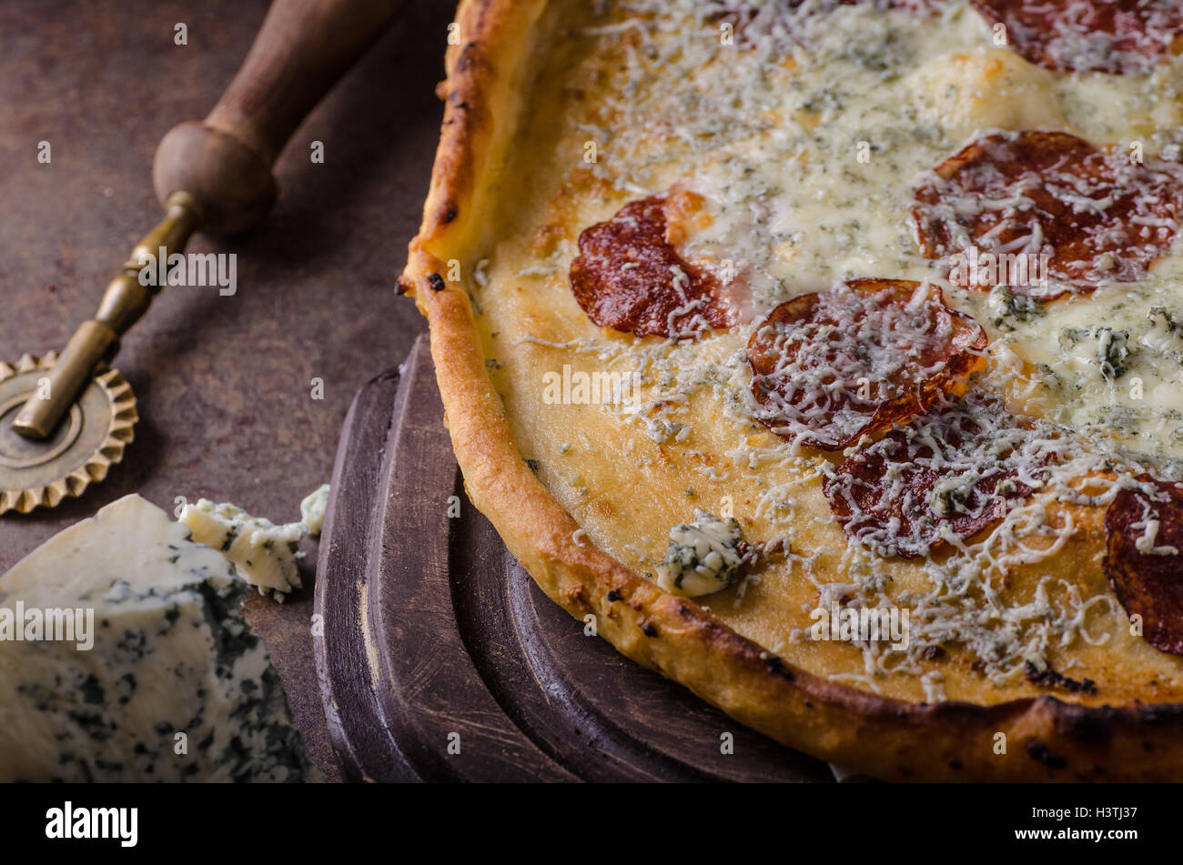 Pizza with blue cheese, rustic with salamy and garlic Stock Photo - Alamy