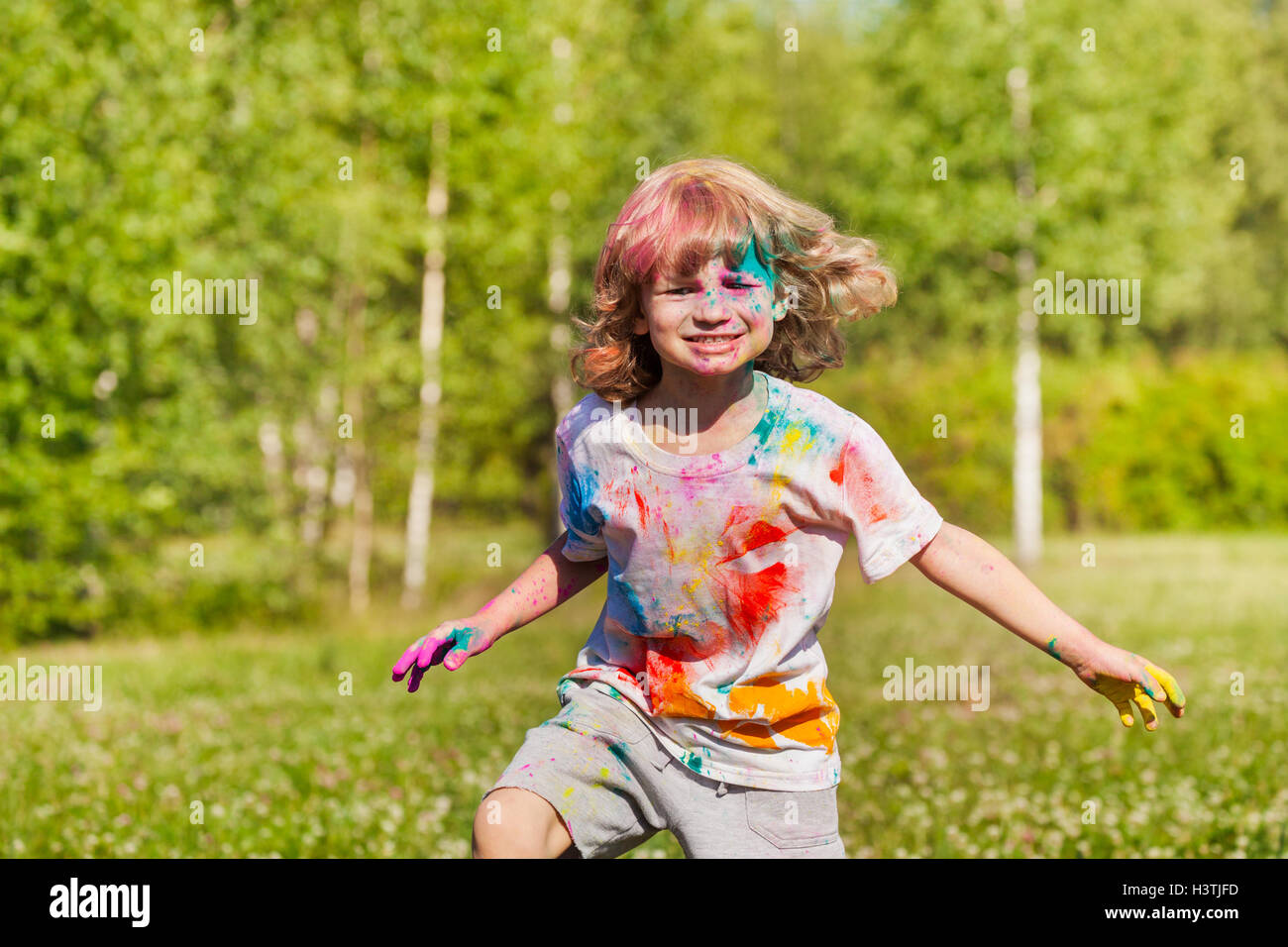 Funny little boy playing with colored powder Stock Photo - Alamy