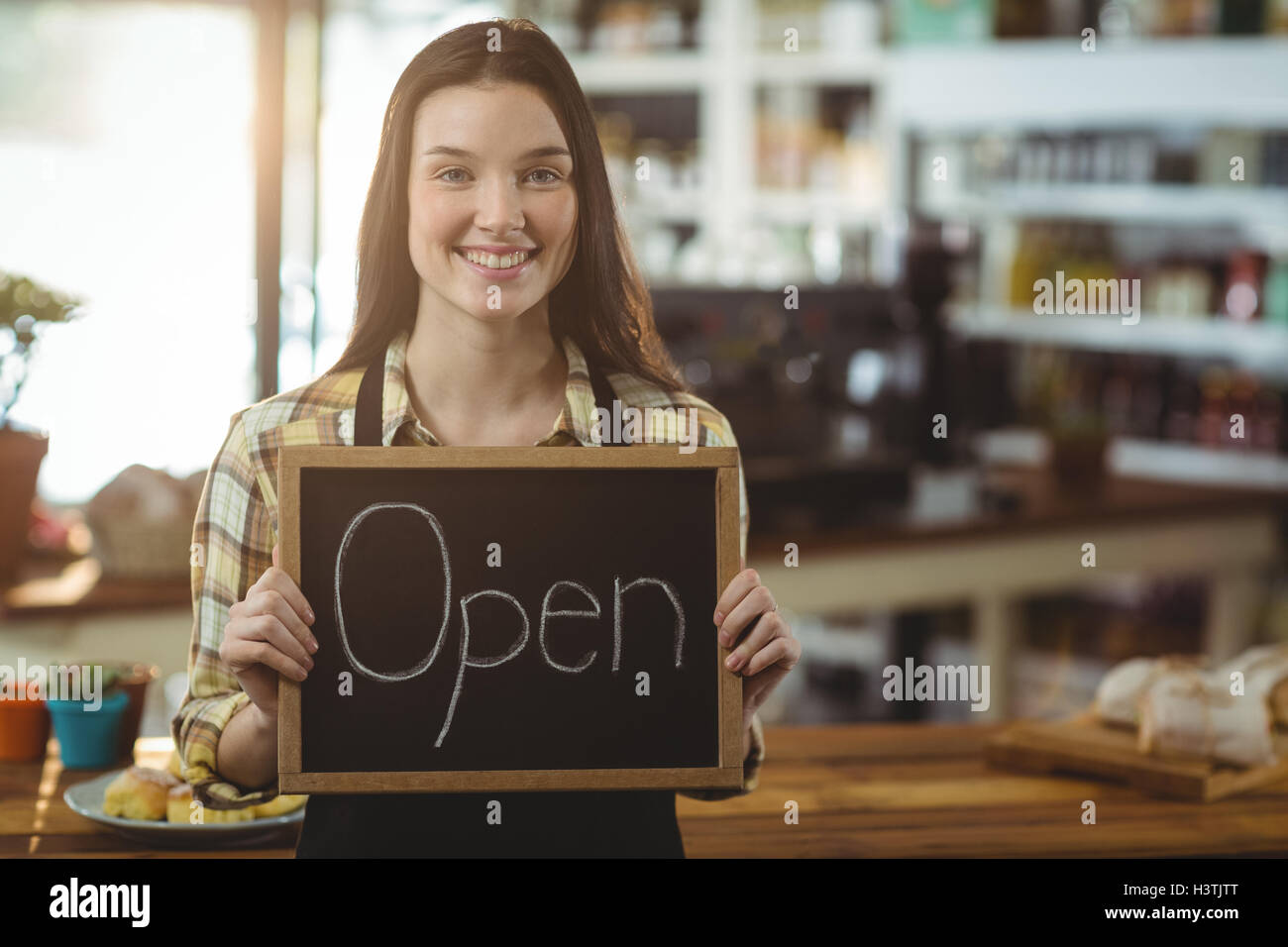 Waitress showing chalkboard open sign hi-res stock photography and ...