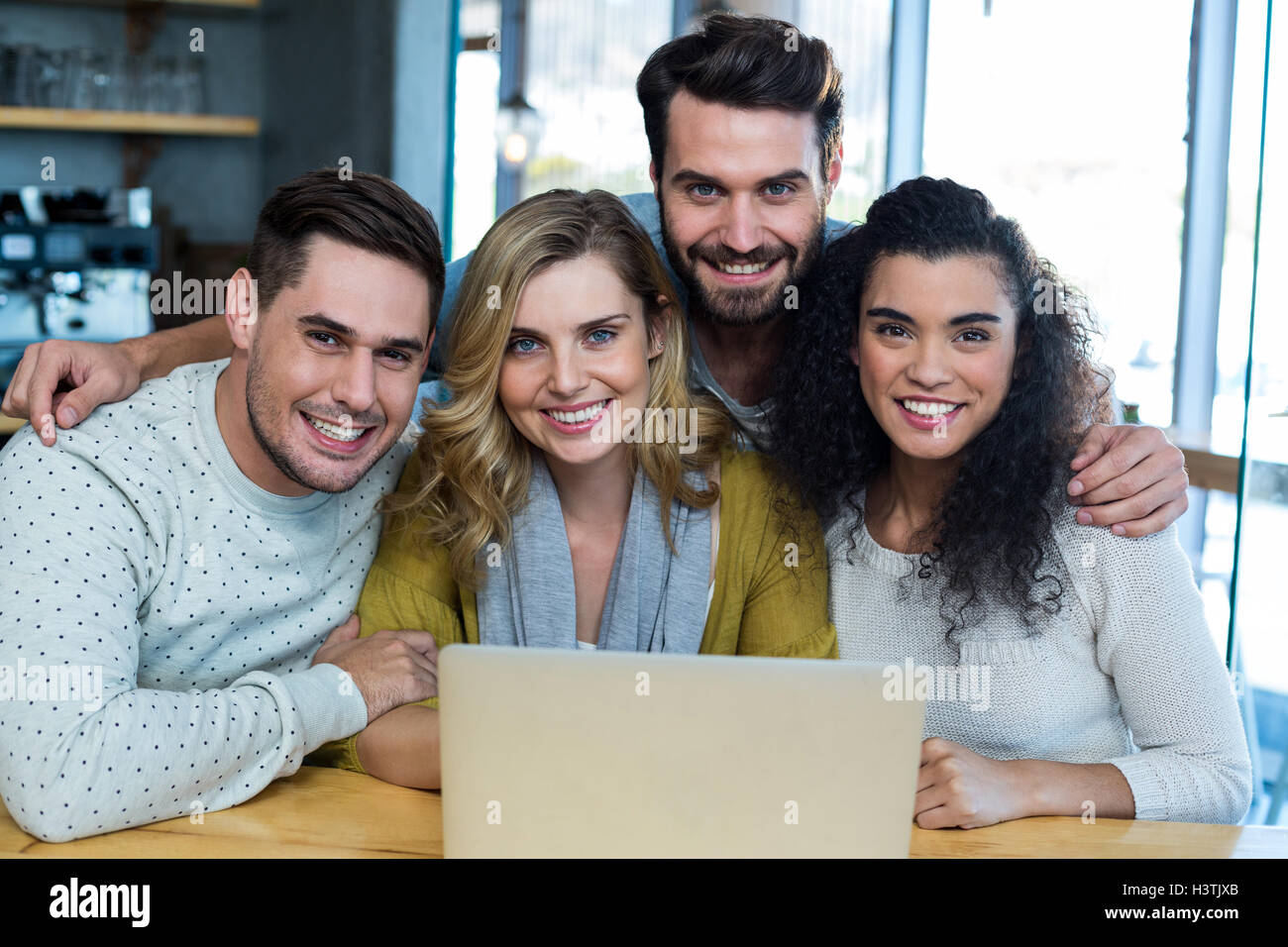 Smiling friends sitting with arm around in caf├⌐ Stock Photo - Alamy