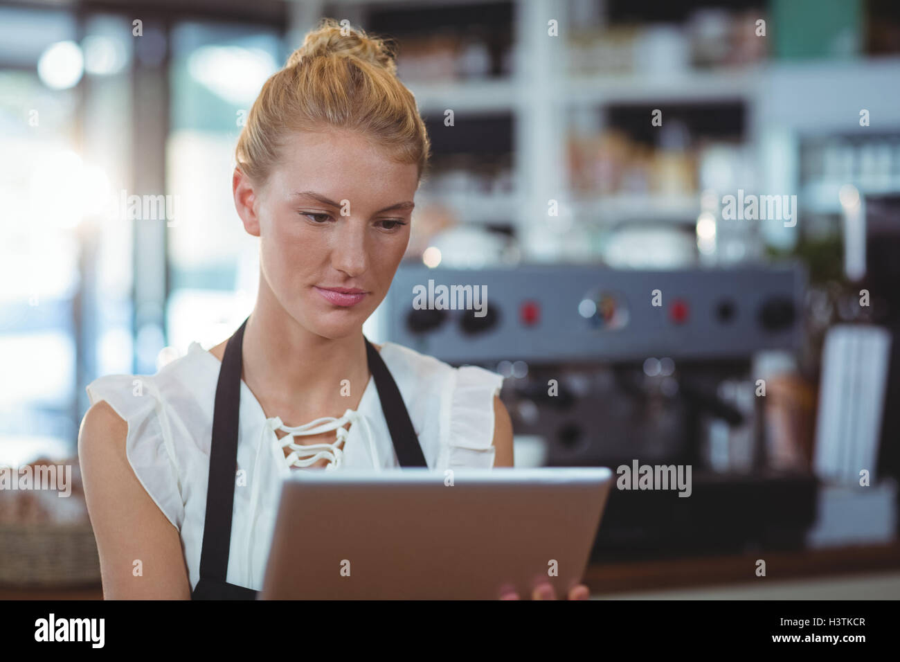 Waitress standing at counter using digital tablet Stock Photo - Alamy