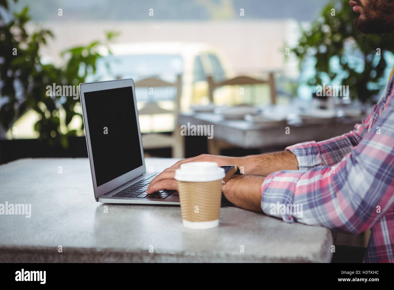 Mid-section of man using laptop Stock Photo - Alamy