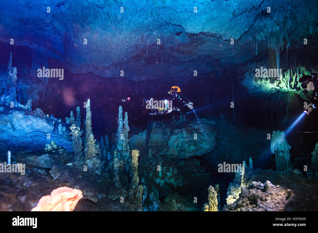 Diver in a cenote cave in Tulum, Mexico, surrounded by turquoise water ...