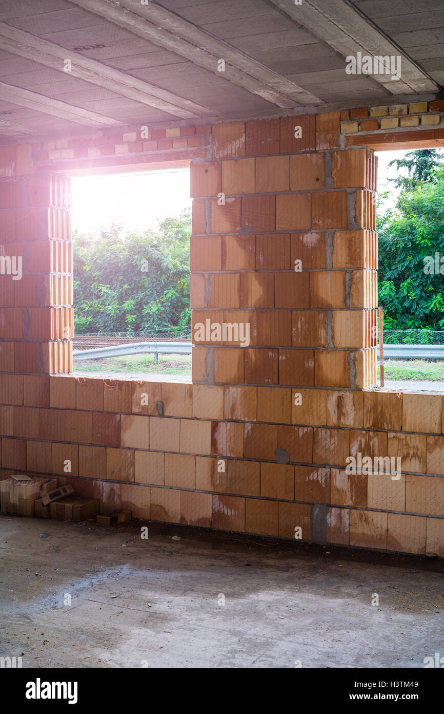 Unfinished brick house interior with big windows Stock Photo - Alamy
