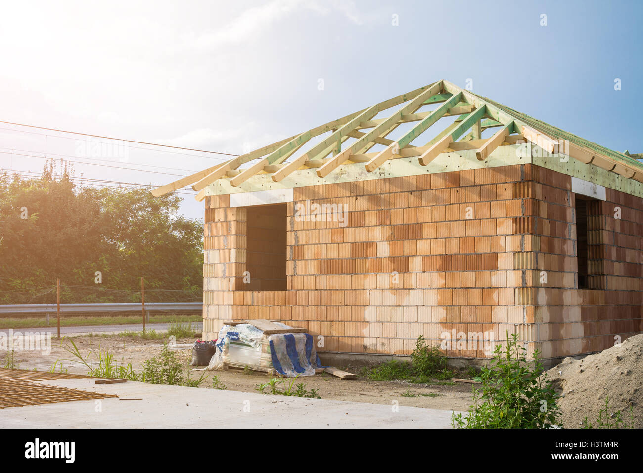 Unfinished brick house with wooden roof structure Stock Photo - Alamy