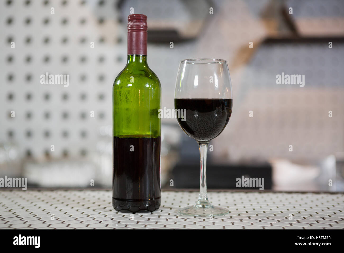 Glass of red wine and bottle on counter Stock Photo - Alamy