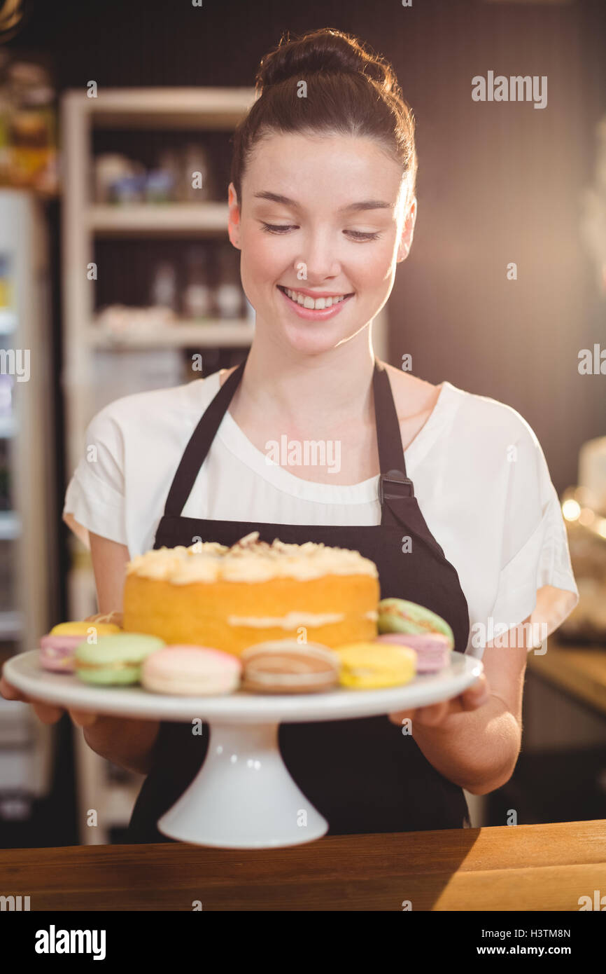 Waitress holding dessert on cake stand in cafe Stock Photo - Alamy