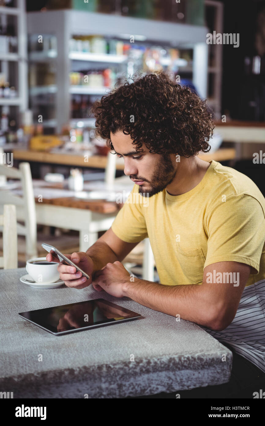 Man using mobile phone while having coffee Stock Photo - Alamy