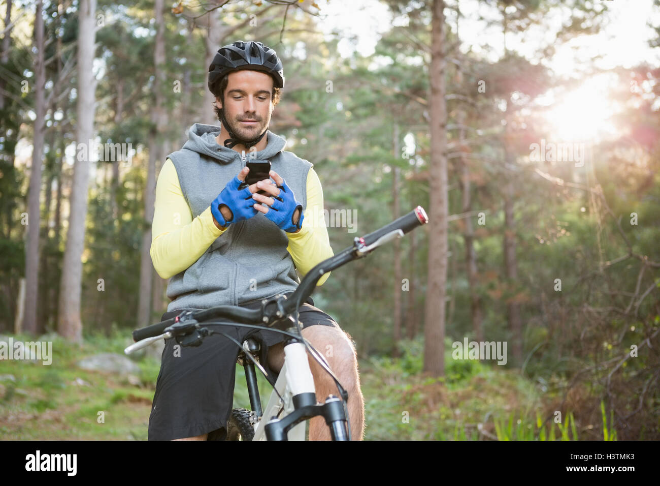 Mountain biker using mobile phone Stock Photo - Alamy