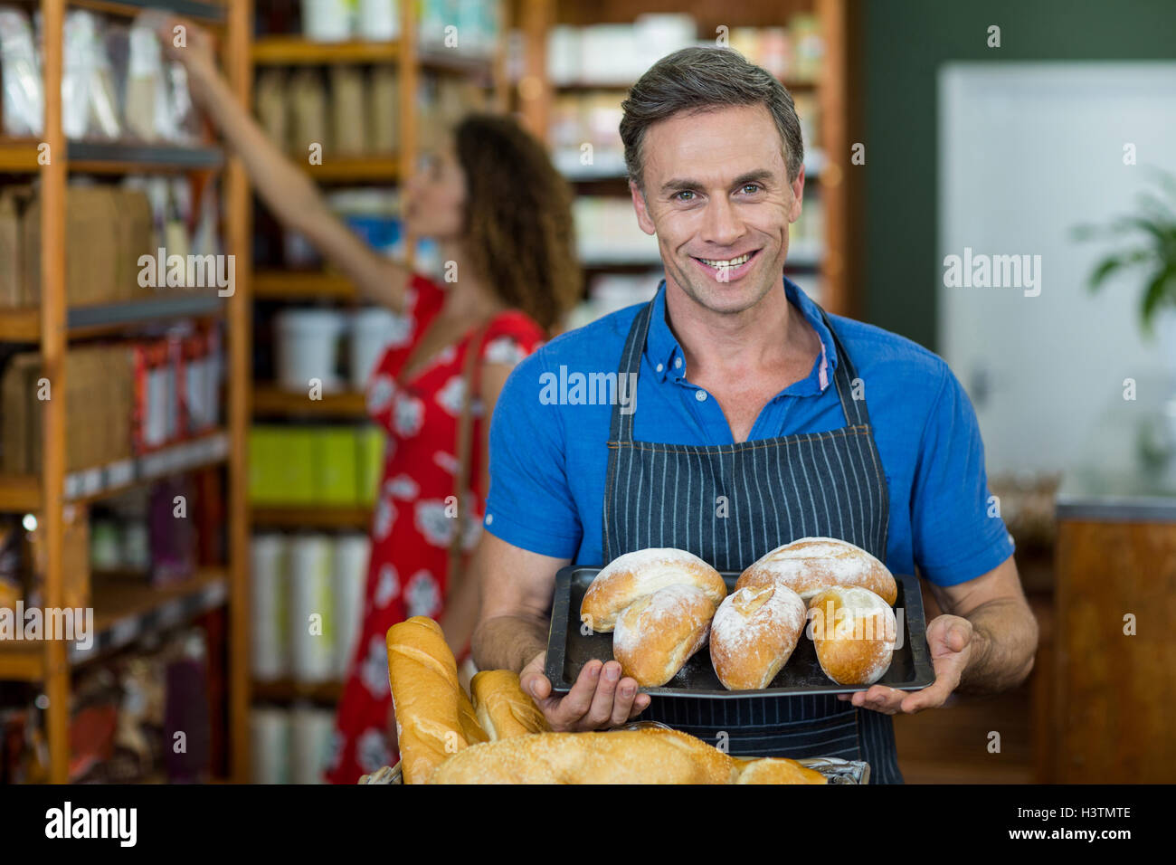 Portrait of male staff holding a tray of bread Stock Photo - Alamy