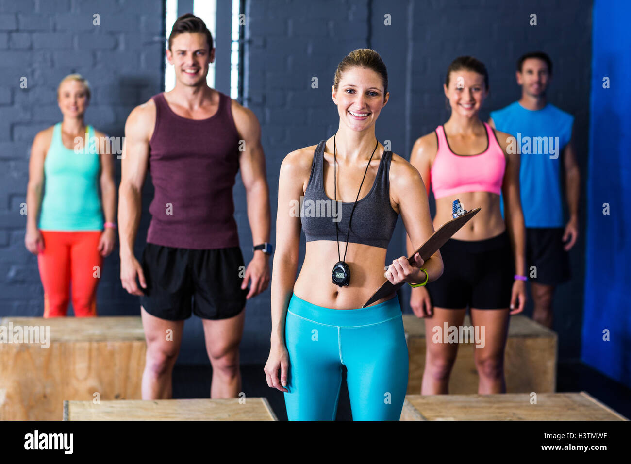 Female trainer with athletes by in fitness studio Stock Photo - Alamy