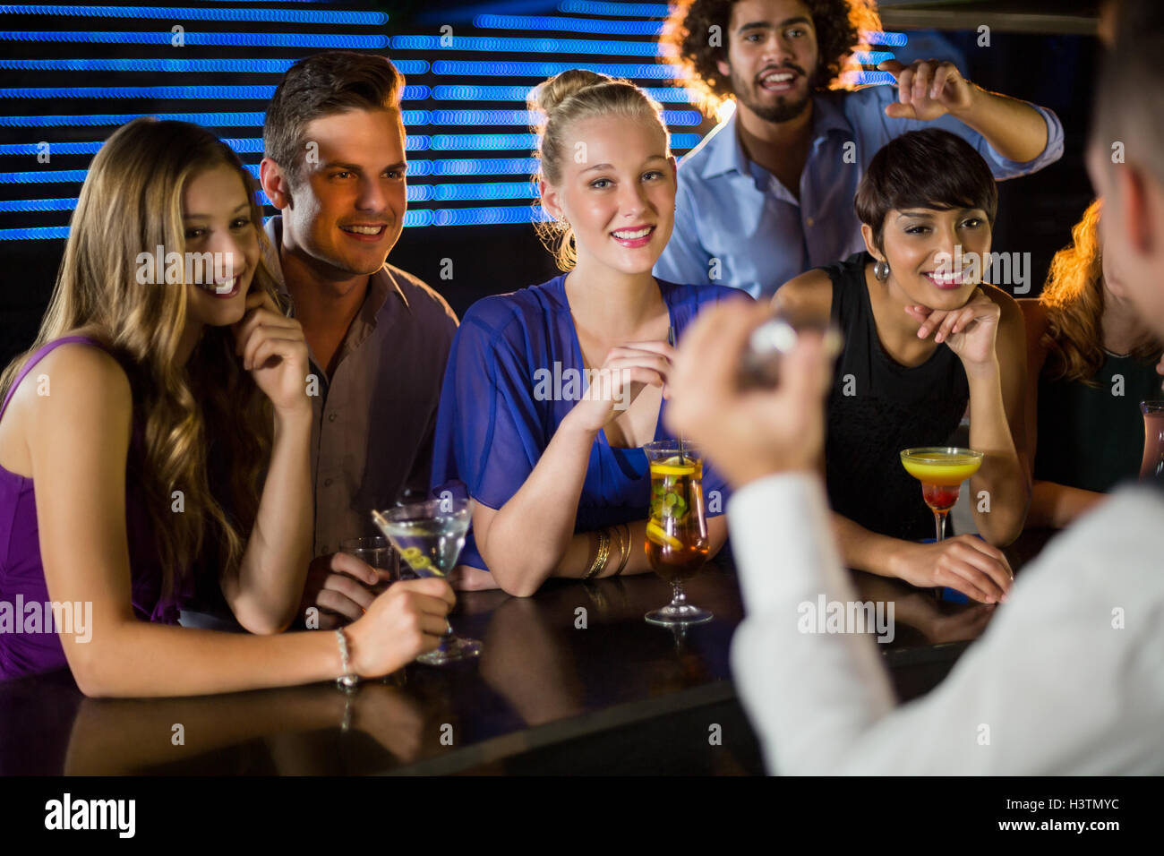 Happy friends standing at bar counter Stock Photo - Alamy