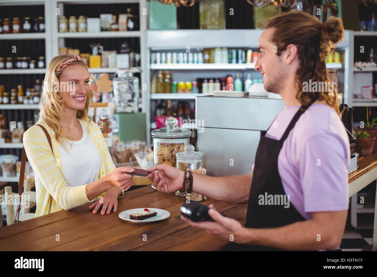 Happy customer giving credit card to waiter Stock Photo - Alamy
