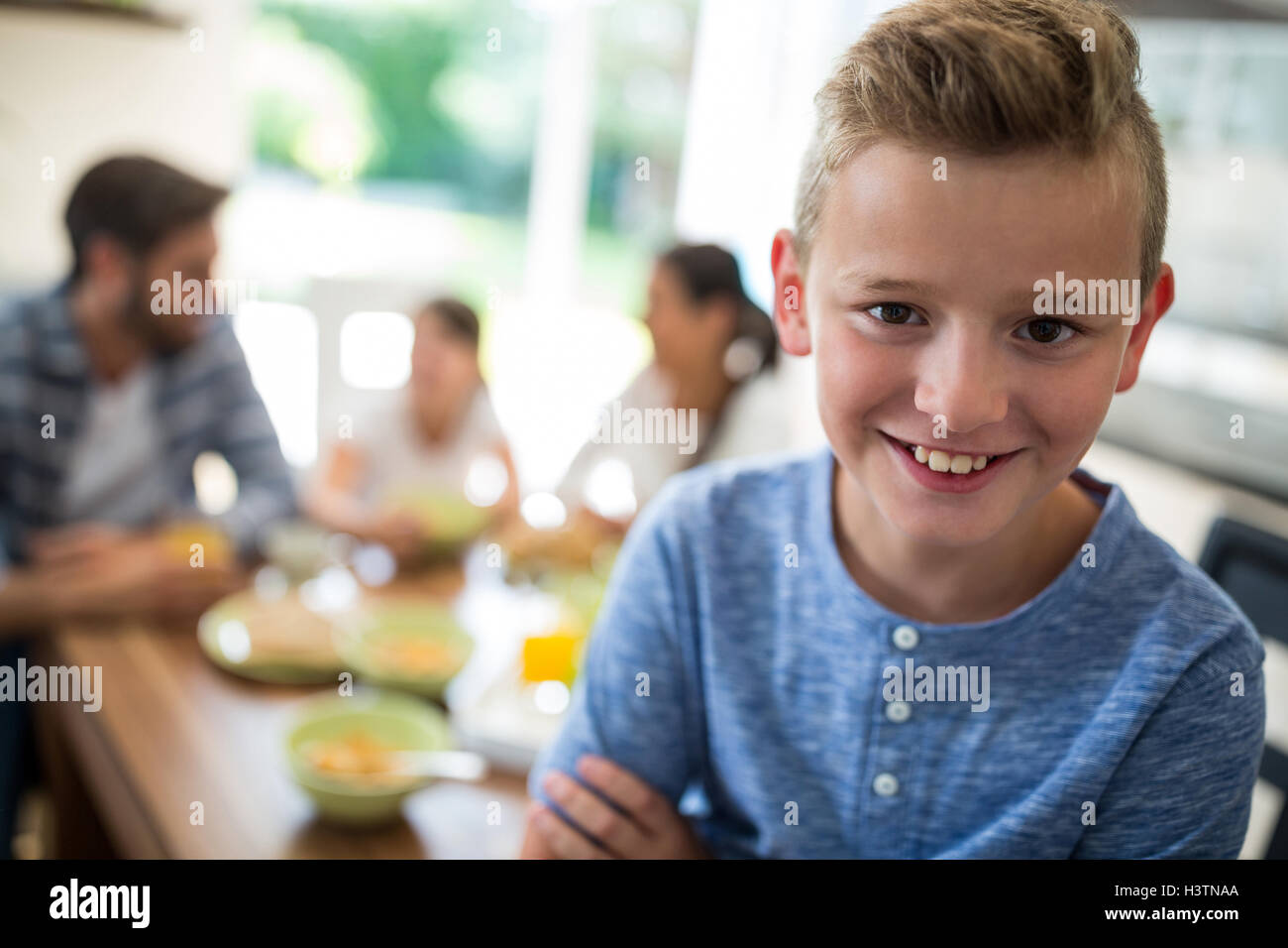 Portrait of boy sitting on dining table Stock Photo - Alamy