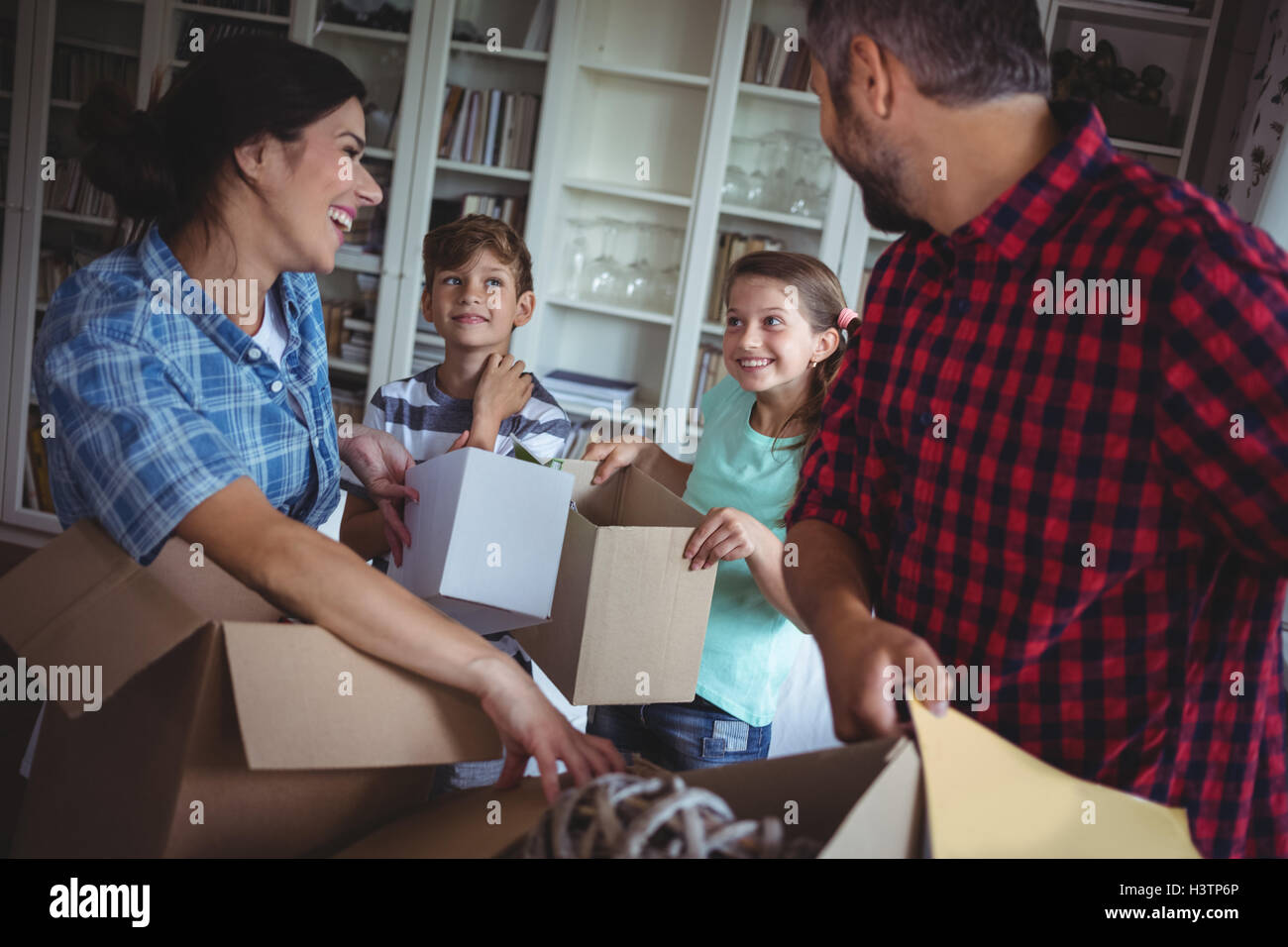 Family unpacking cartons together Stock Photo - Alamy