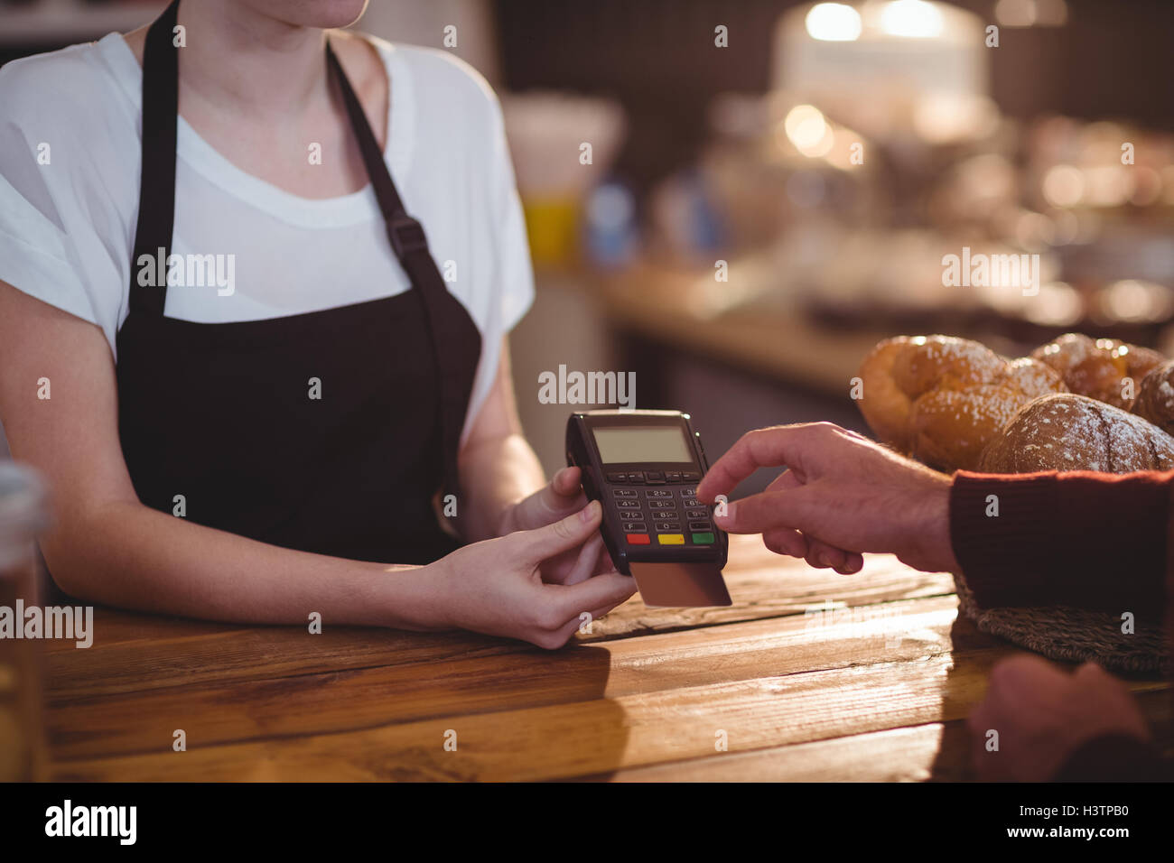 Customer entering pin number into machine at counter Stock Photo - Alamy