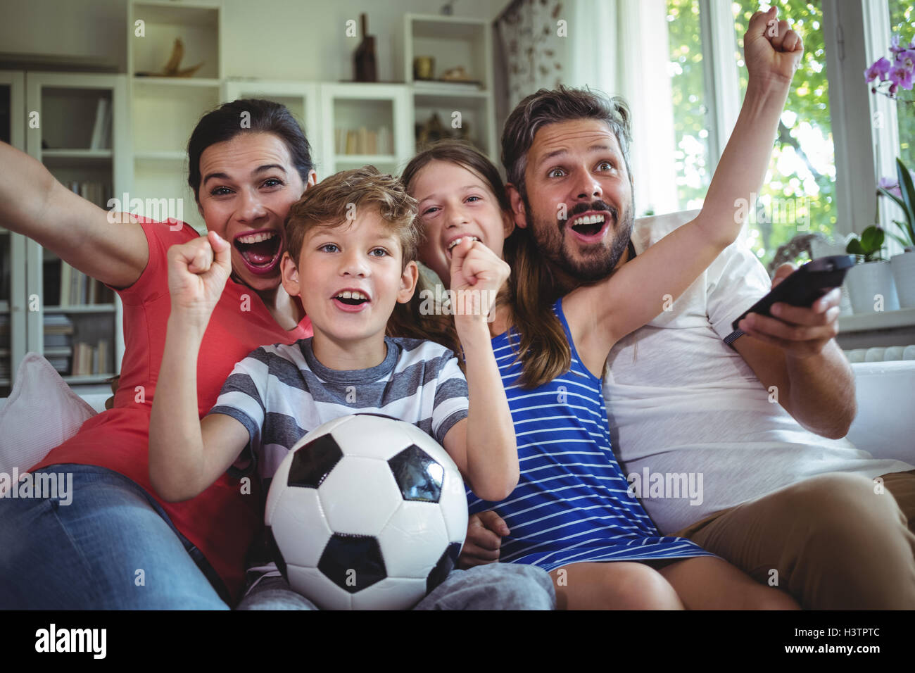 Excited family watching football match Stock Photo - Alamy