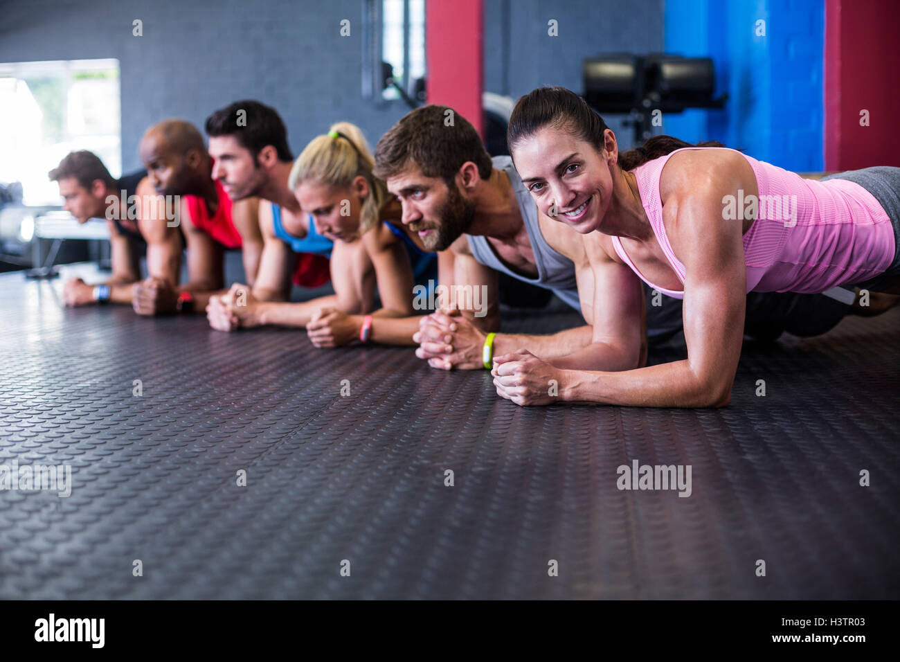 Portrait of smiling woman exercising with friends in gym Stock Photo ...
