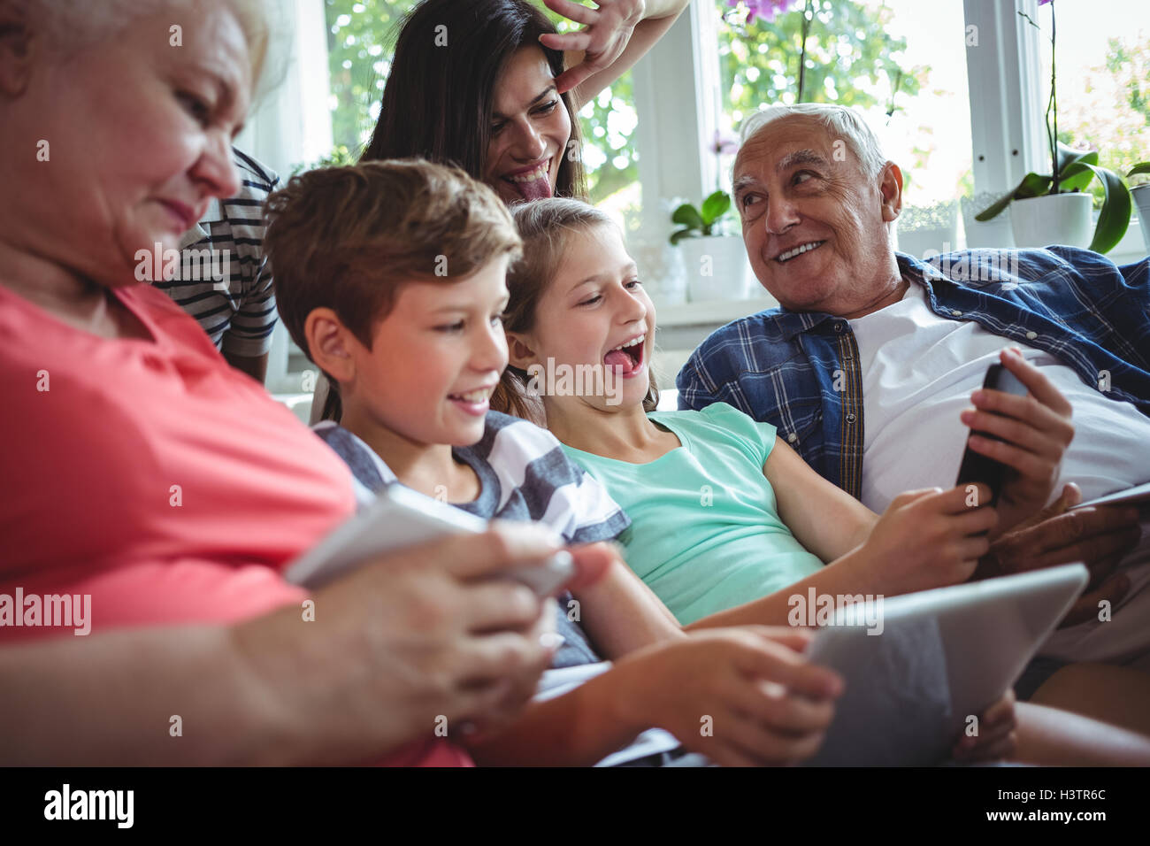 Happy multi-generation family sitting together in living room Stock ...