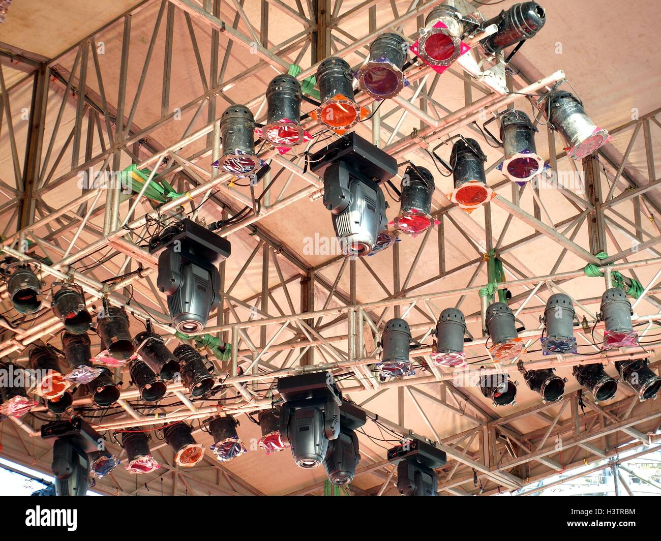 Multi-color spotlights and projectors form a complex stage lighting ...