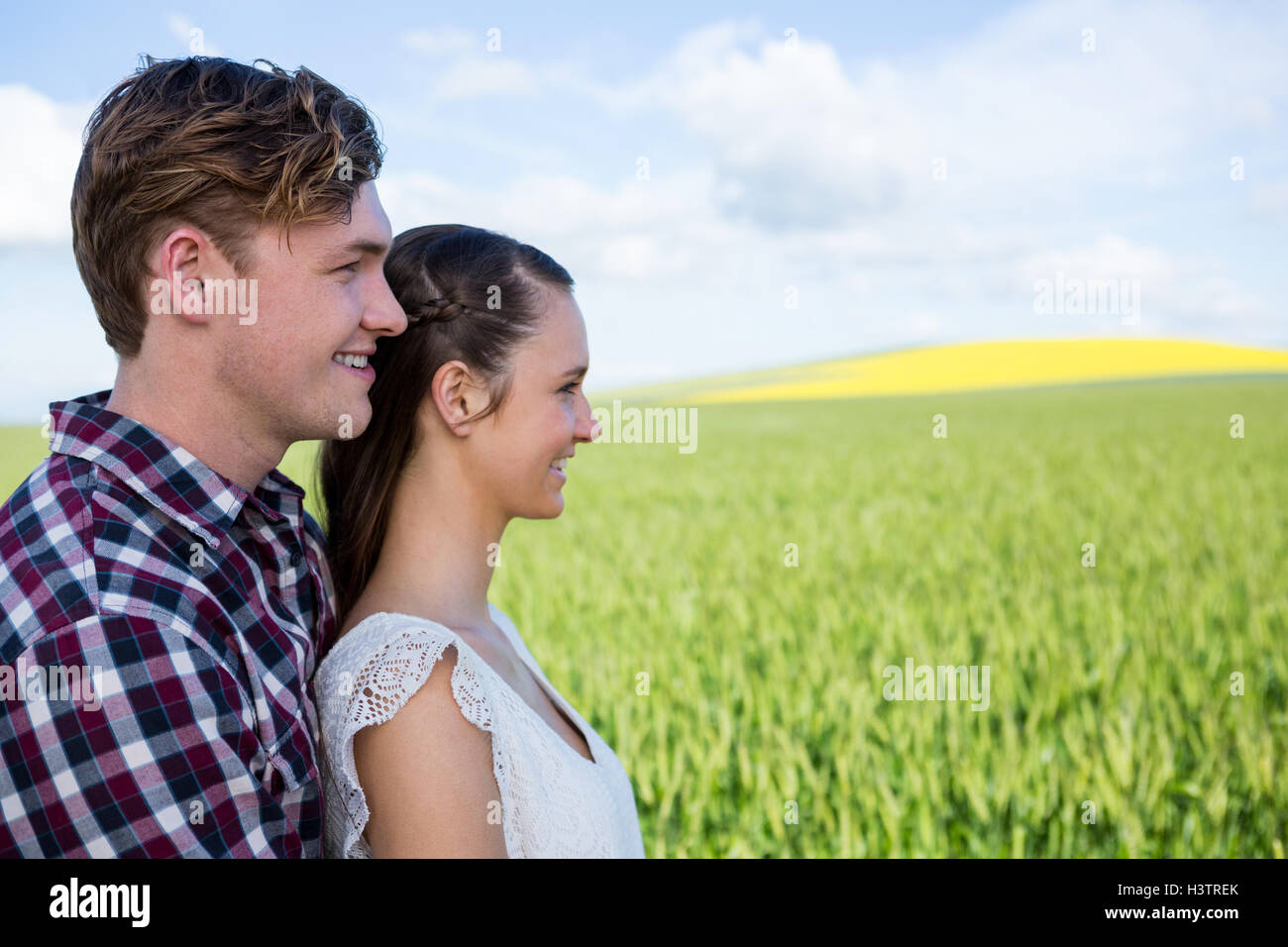 Romantic couple standing in field Stock Photo - Alamy
