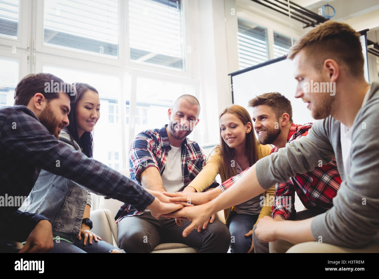 Creative business people stacking hands in meeting room Stock Photo - Alamy