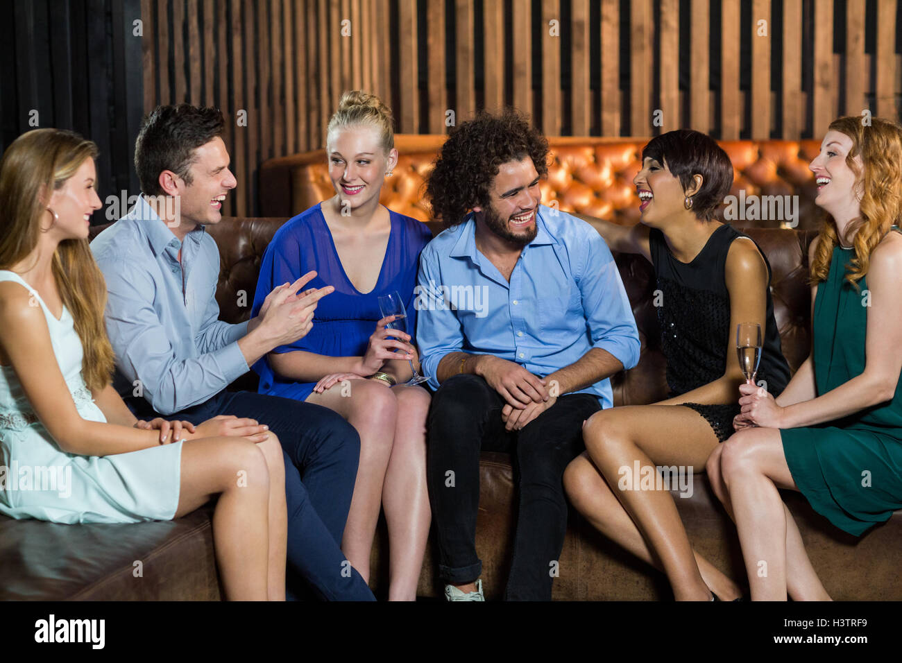 Smiling friends interacting with each other Stock Photo - Alamy