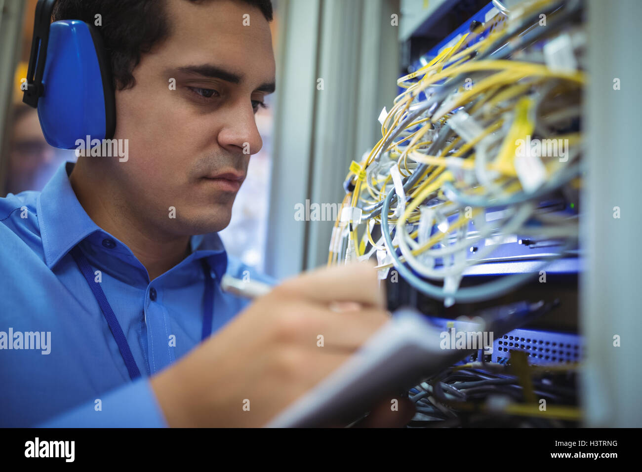 Technician maintaining record of rack mounted server on clipboard Stock ...