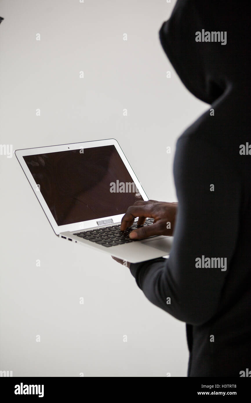 Hacker using a laptop Stock Photo - Alamy
