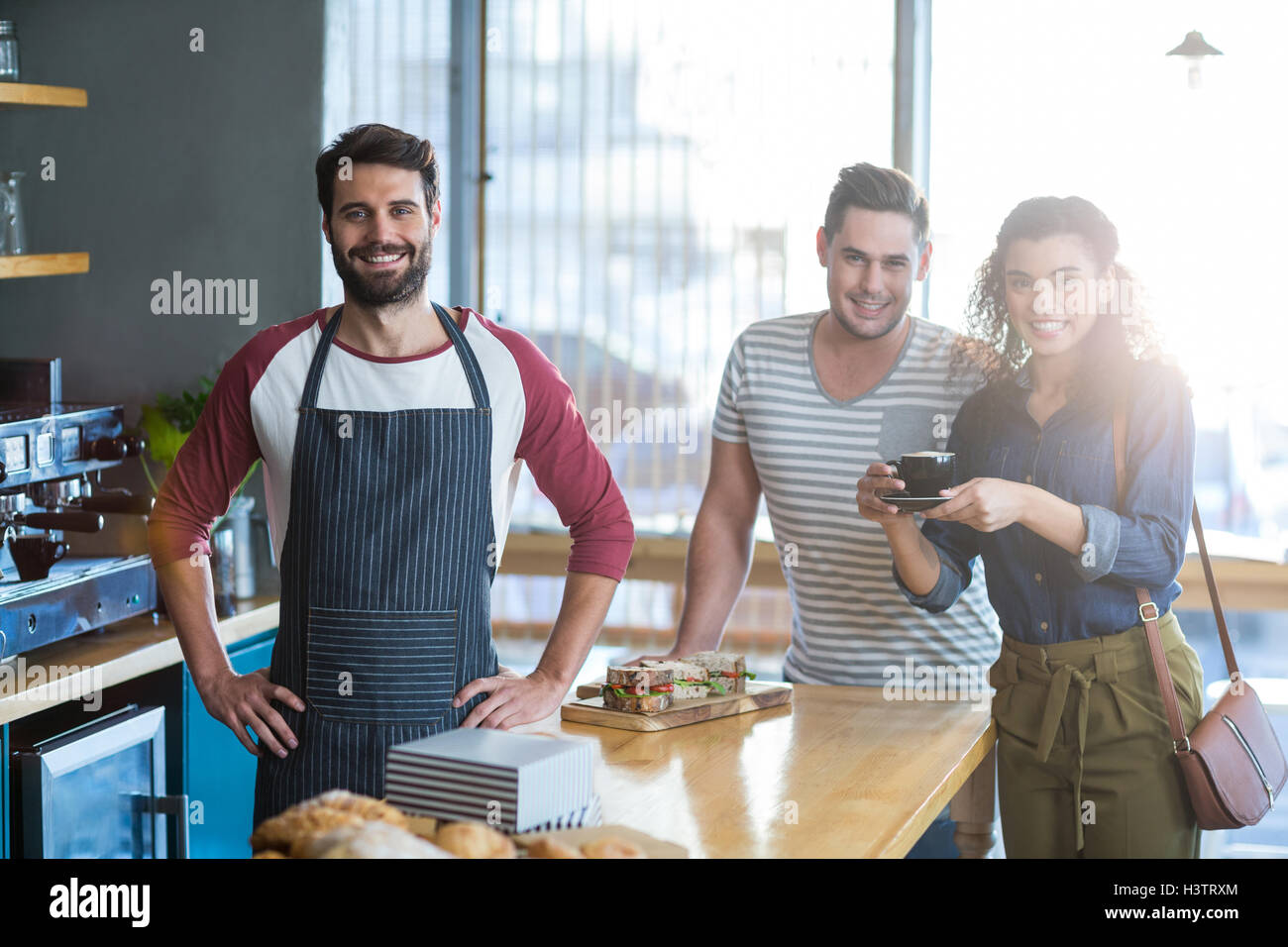 Waiter and customers standing at counter in caf├⌐ Stock Photo - Alamy