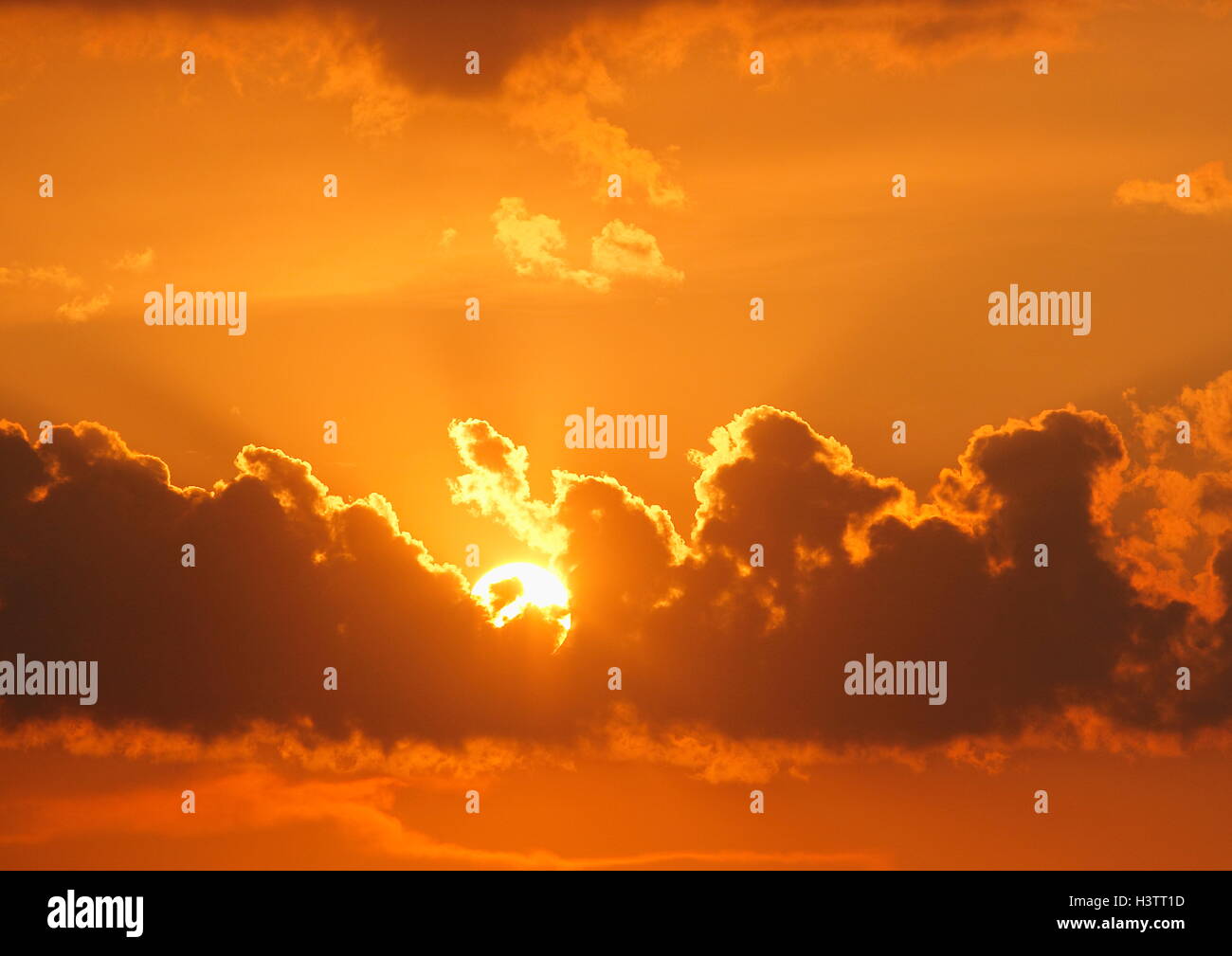 Atmospheric sunset, sun behind dark clouds Stock Photo - Alamy
