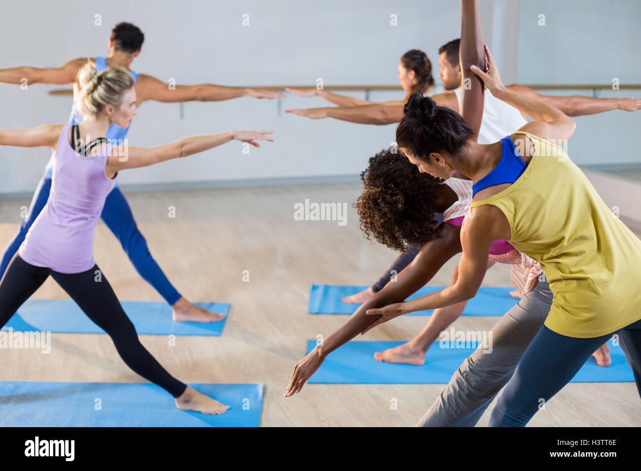 Yoga instructor helping student with a correct pose Stock Photo - Alamy