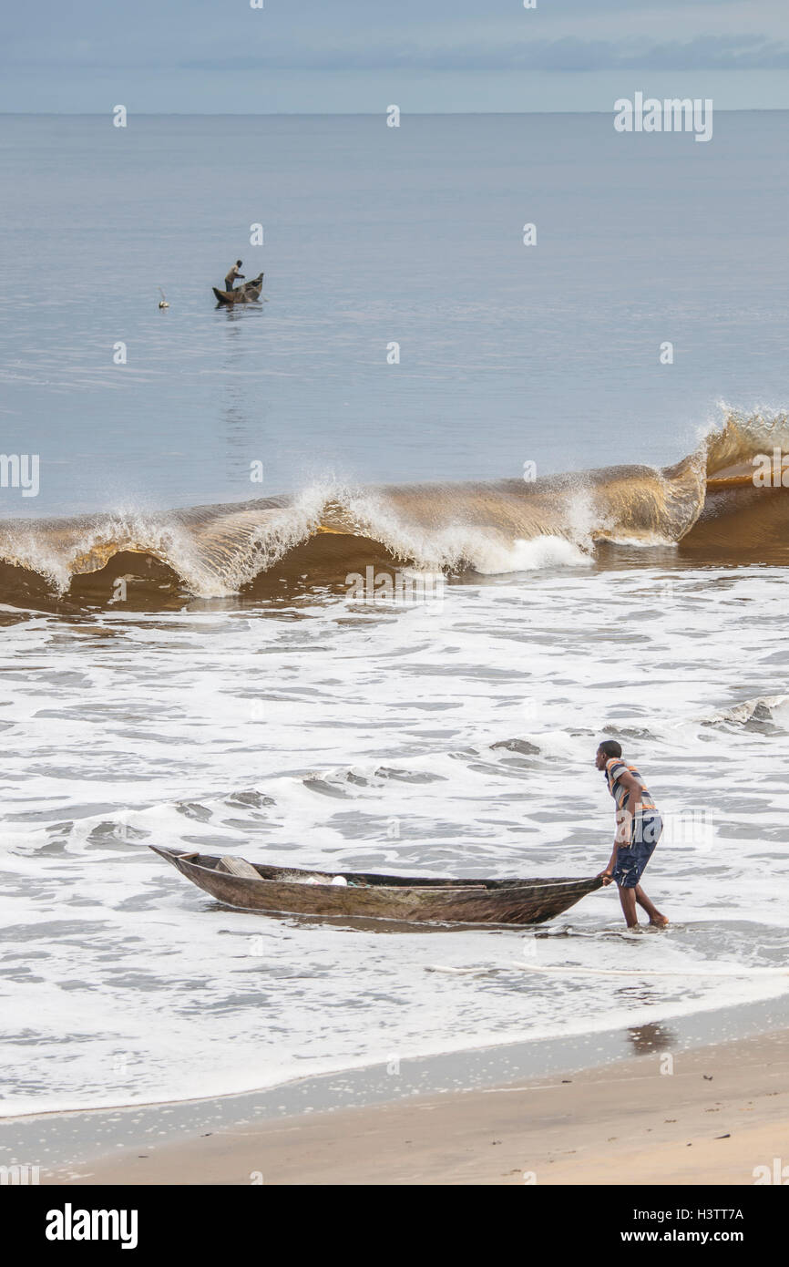 Fisherman with a dugout canoe on the beach, Kribi, South Region ...
