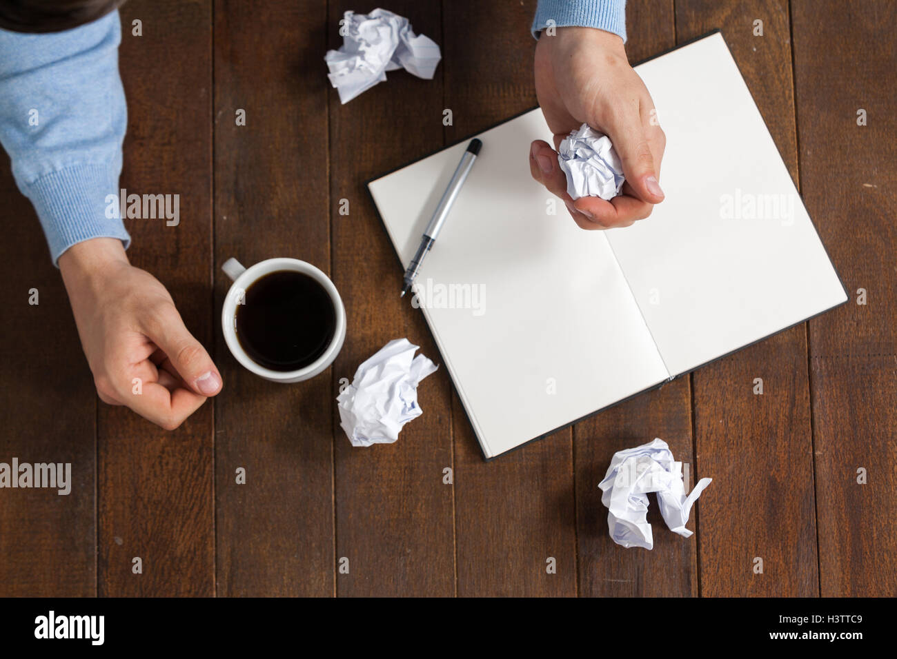 Man crumpling paper while having cup of coffee Stock Photo - Alamy