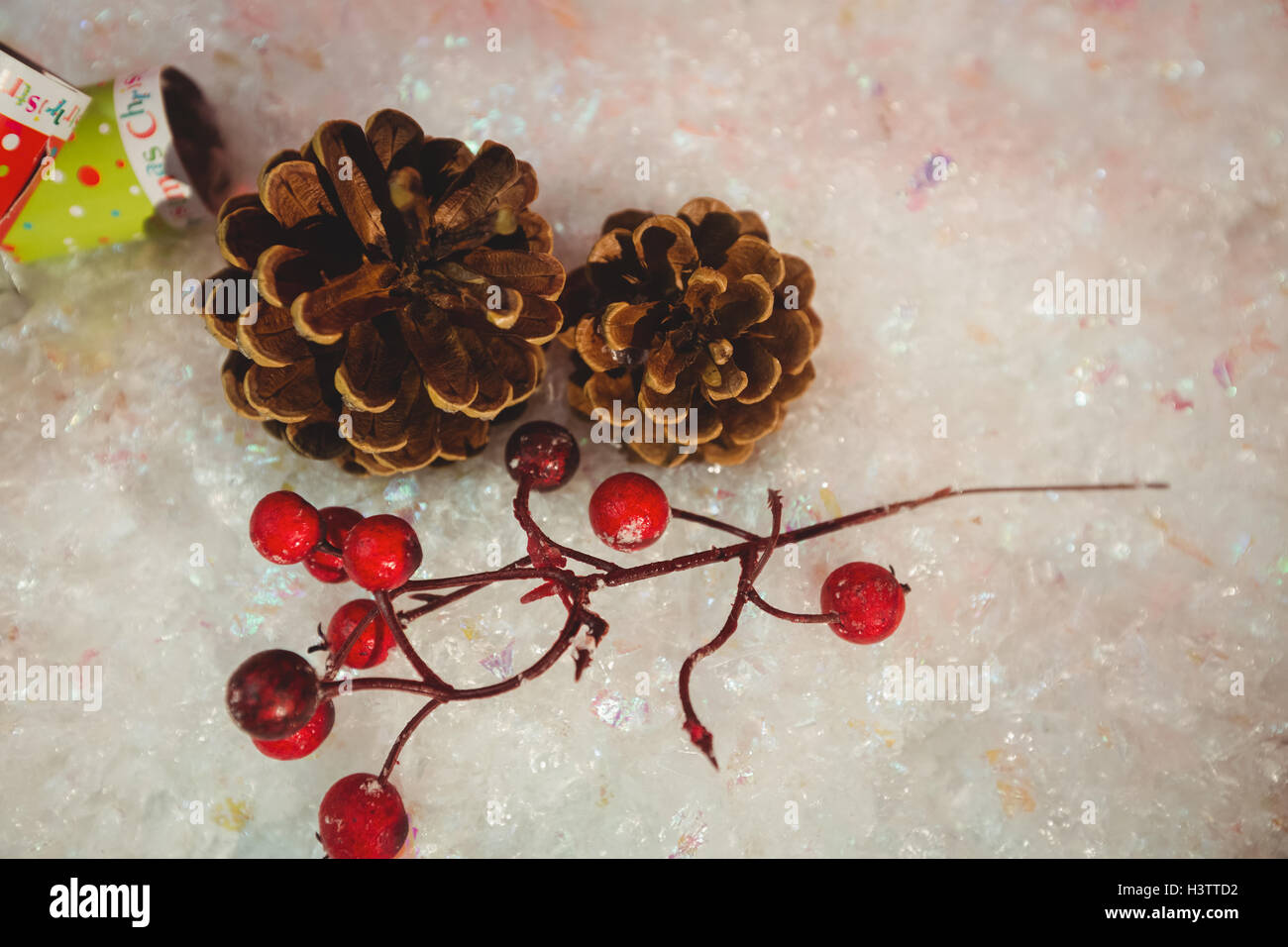 Pine cone, cherry and christmas crackers on snow Stock Photo - Alamy