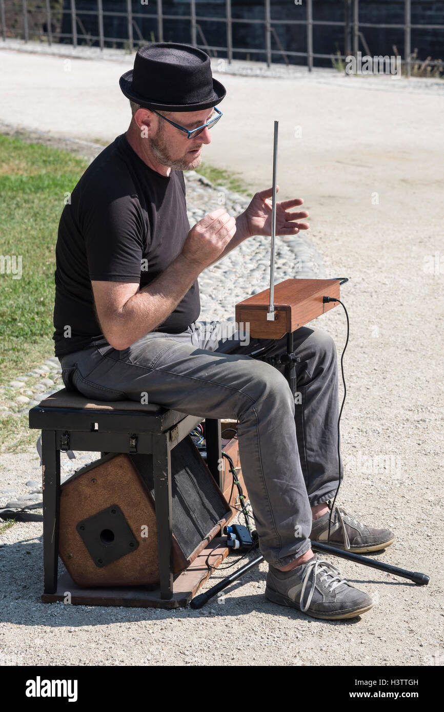 A street musician plays the unusual electronic musical instrument ...