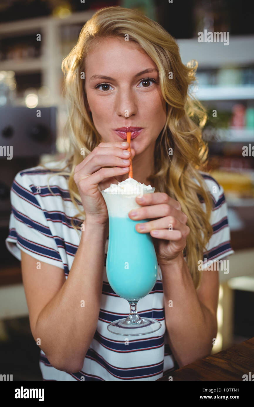 Portrait of woman drinking milkshake with a straw Stock Photo - Alamy