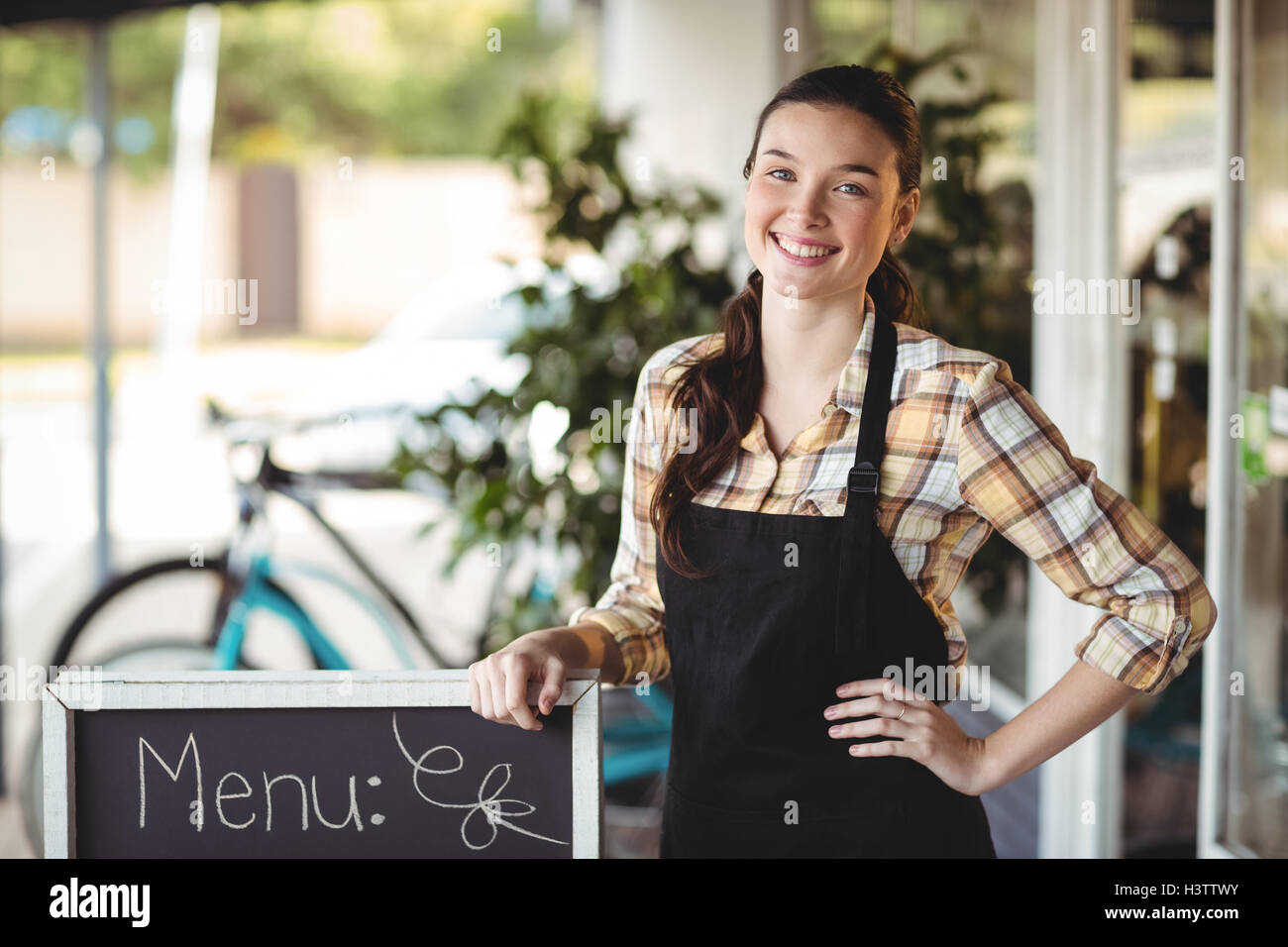 Waitress standing with menu board outside the cafe Stock Photo - Alamy