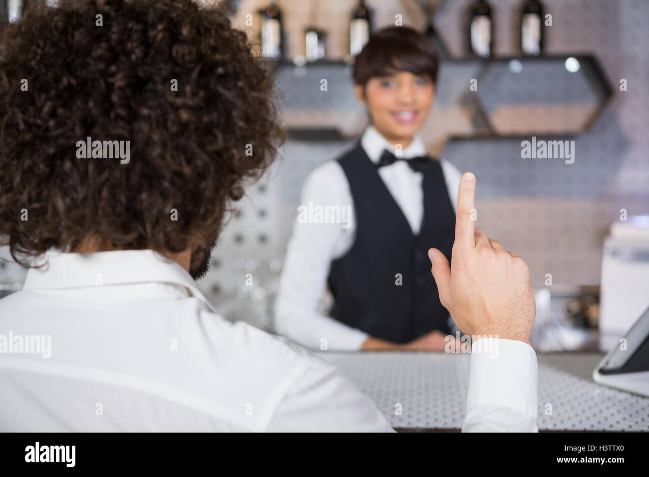 Man ordering a drink at bar counter Stock Photo - Alamy