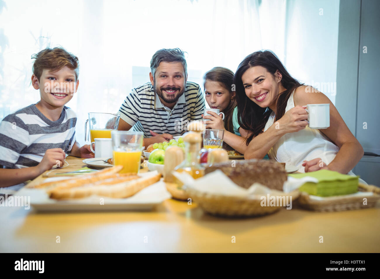 Portrait of happy family having breakfast together Stock Photo - Alamy