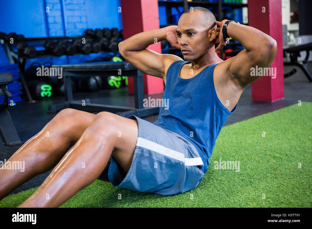 Young male athlete with hands behind back in gym Stock Photo - Alamy