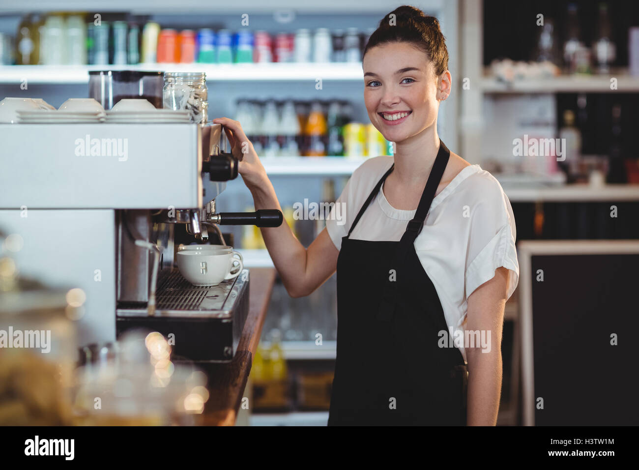 Smiling waitress making cup of coffee Stock Photo - Alamy