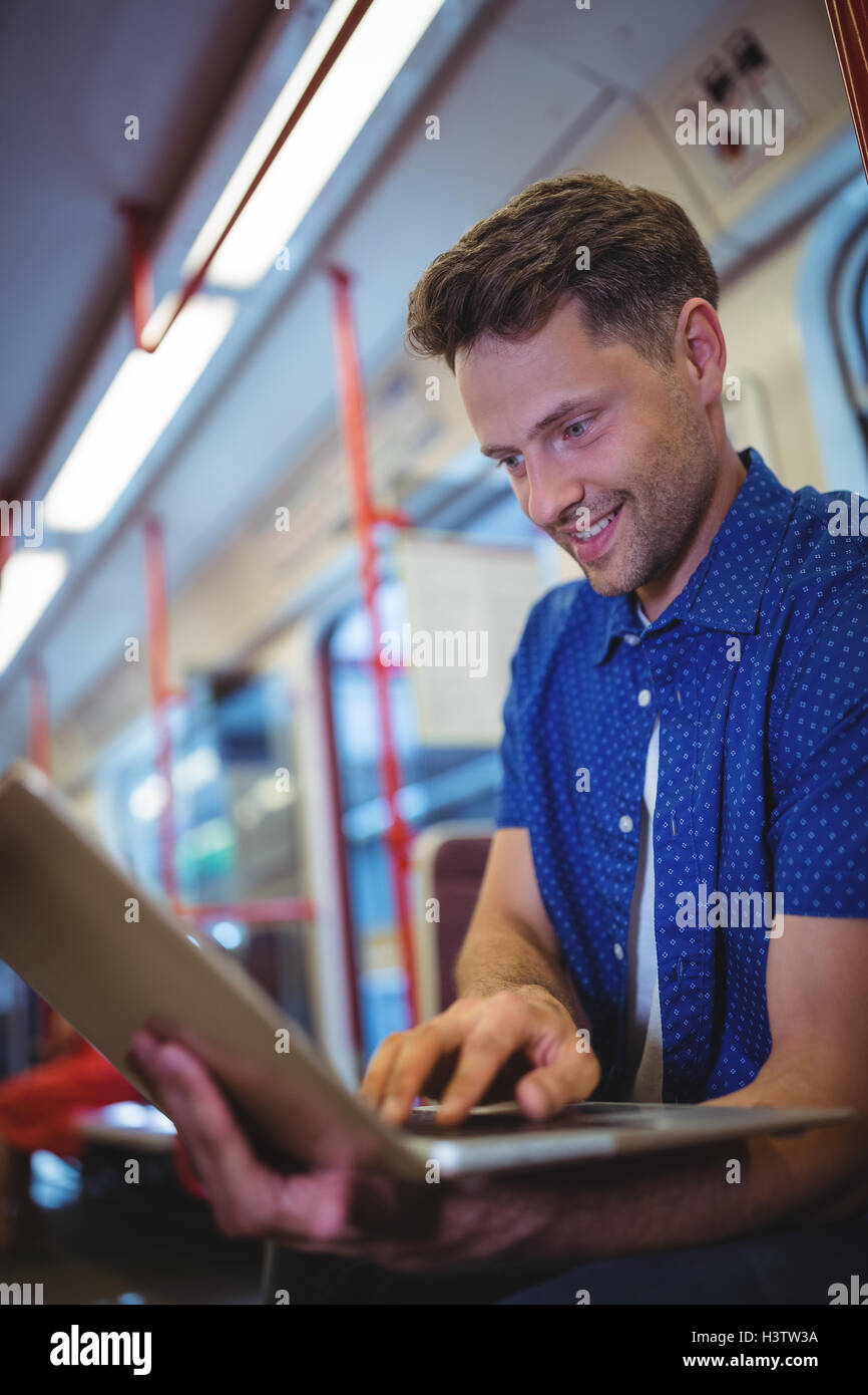 Handsome man using laptop in train Stock Photo - Alamy