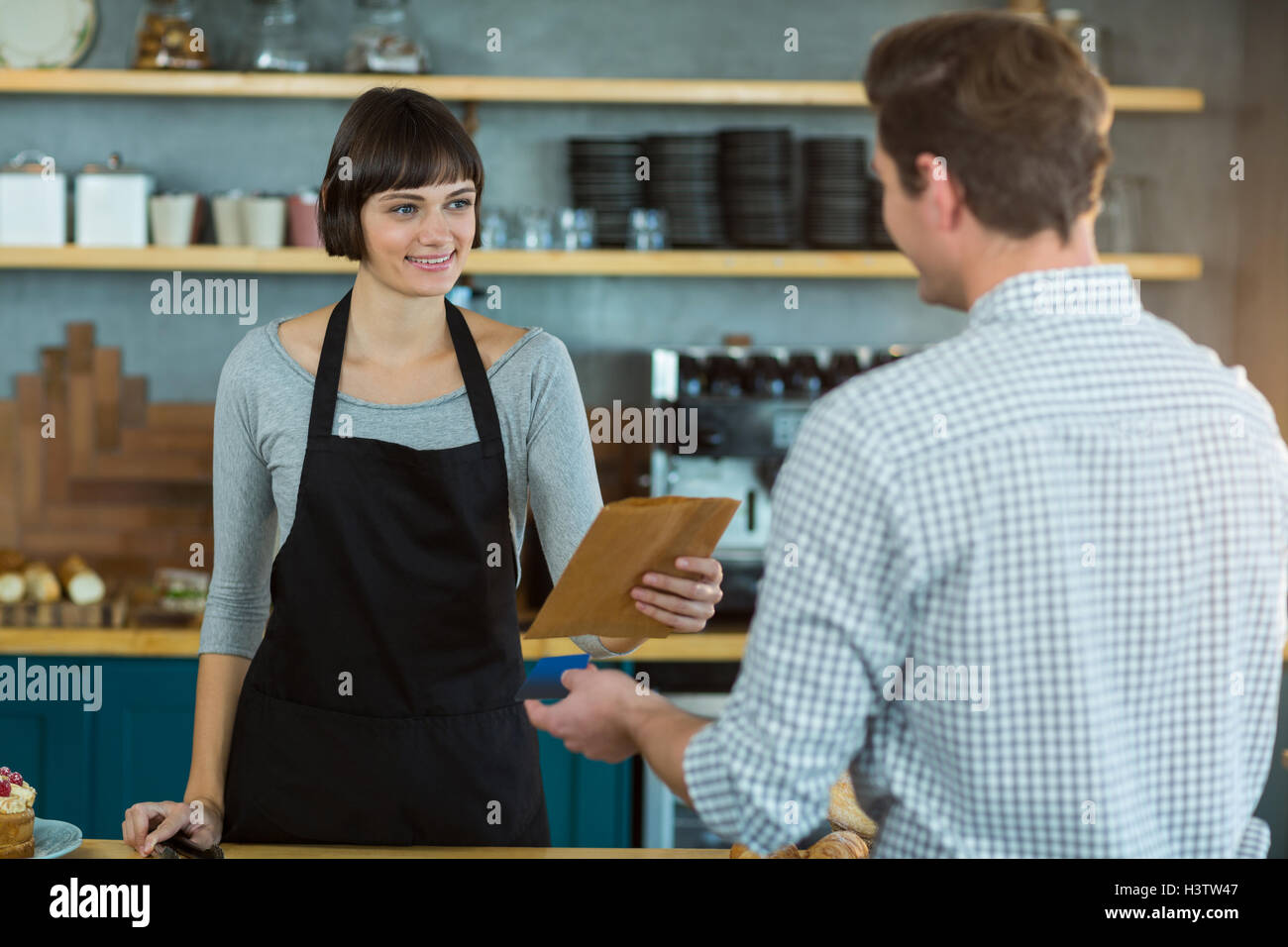 Waitress giving parcel to customer at counter Stock Photo - Alamy